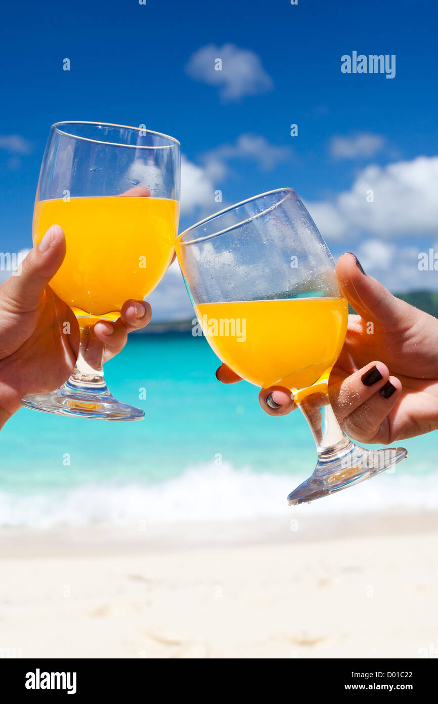 Cocktails on beach in female hands, cheers Stock Photo - Alamy