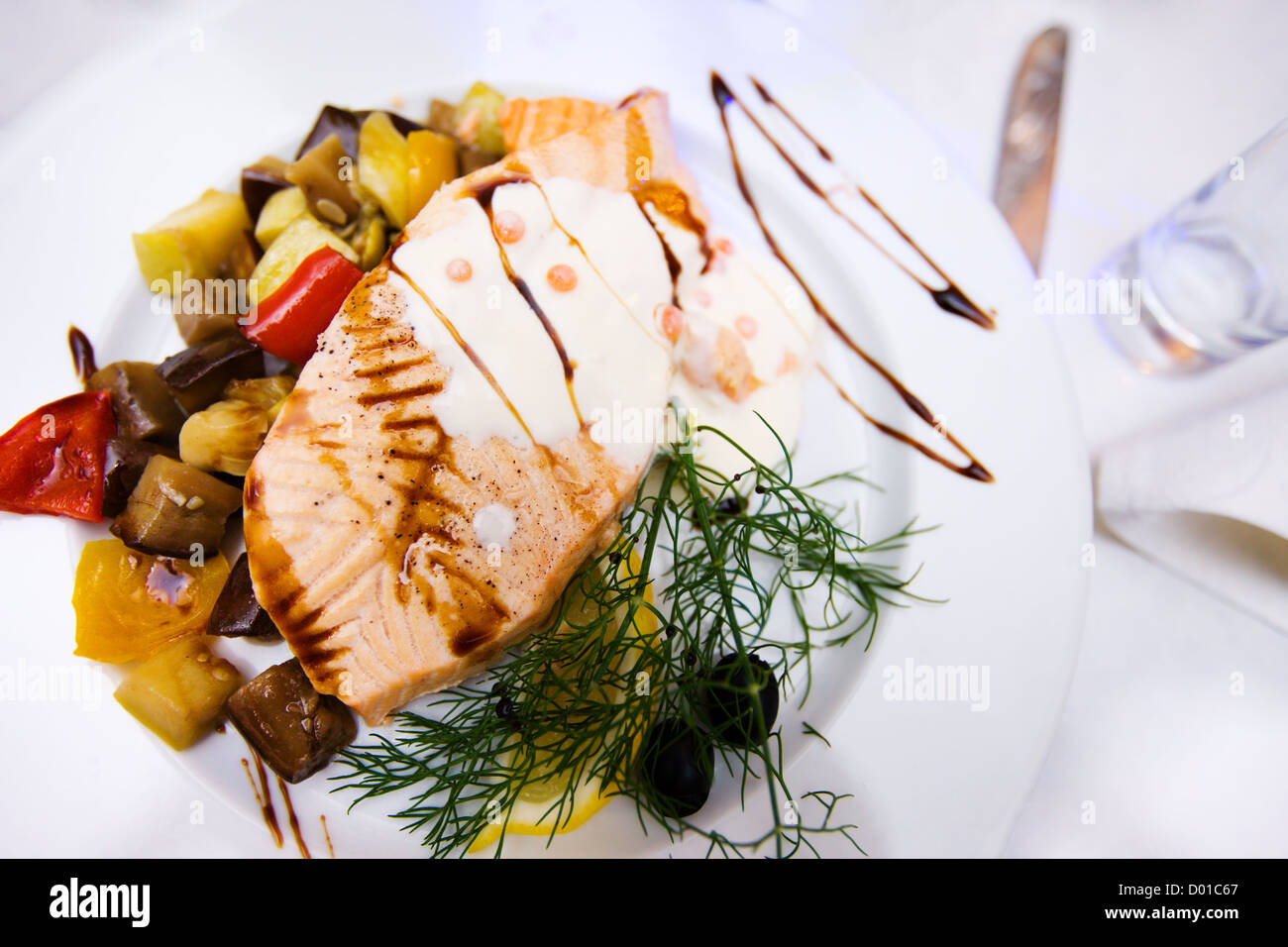 Salmon fish dish decorated on white plate in restaurant Stock Photo - Alamy