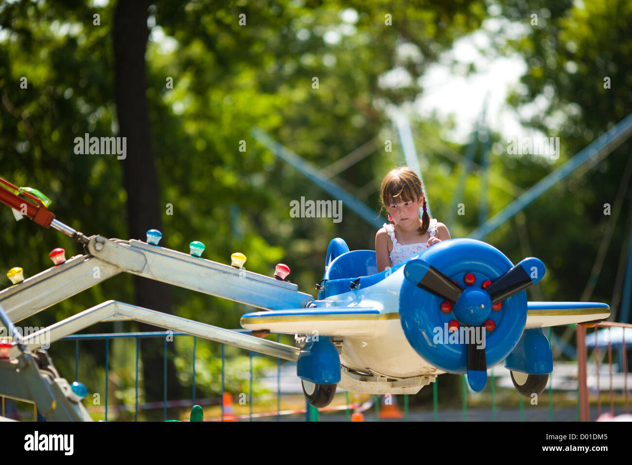 Happy little girl riding carousel in toy airplane Stock Photo - Alamy