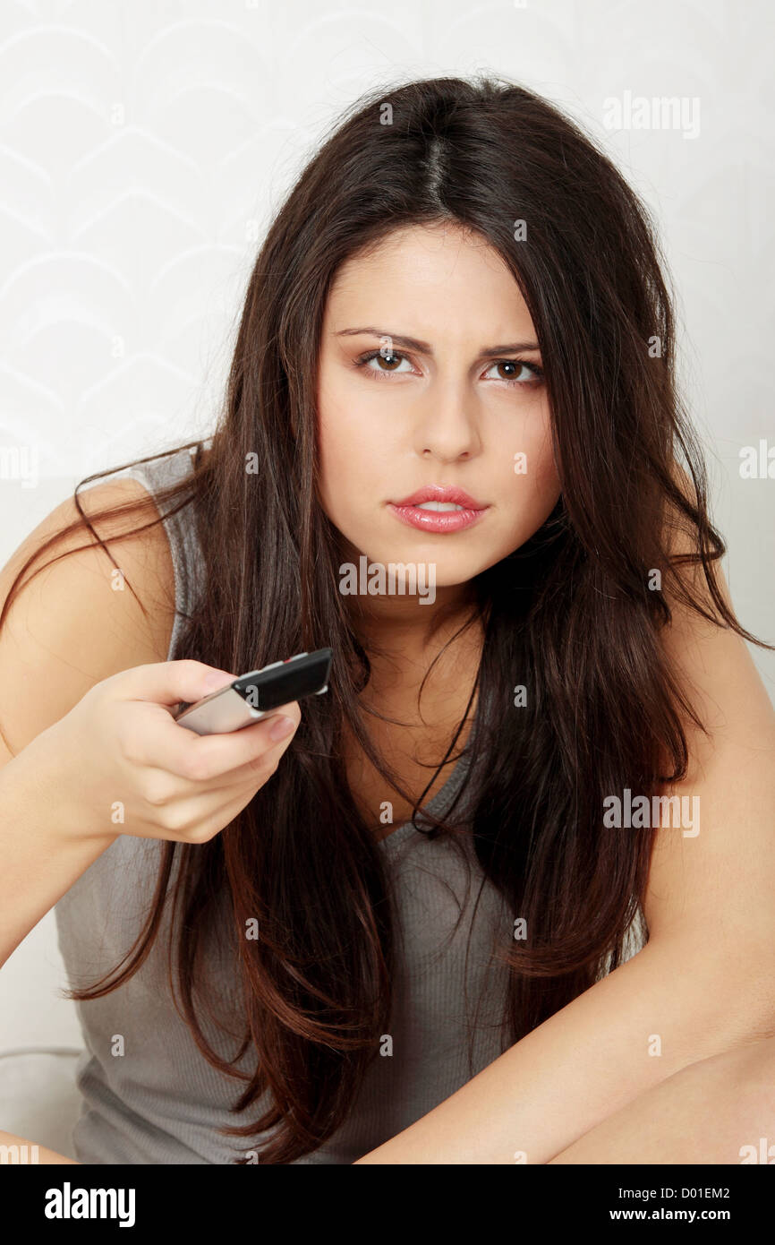 Woman in living room with remote control watching tv Stock Photo - Alamy