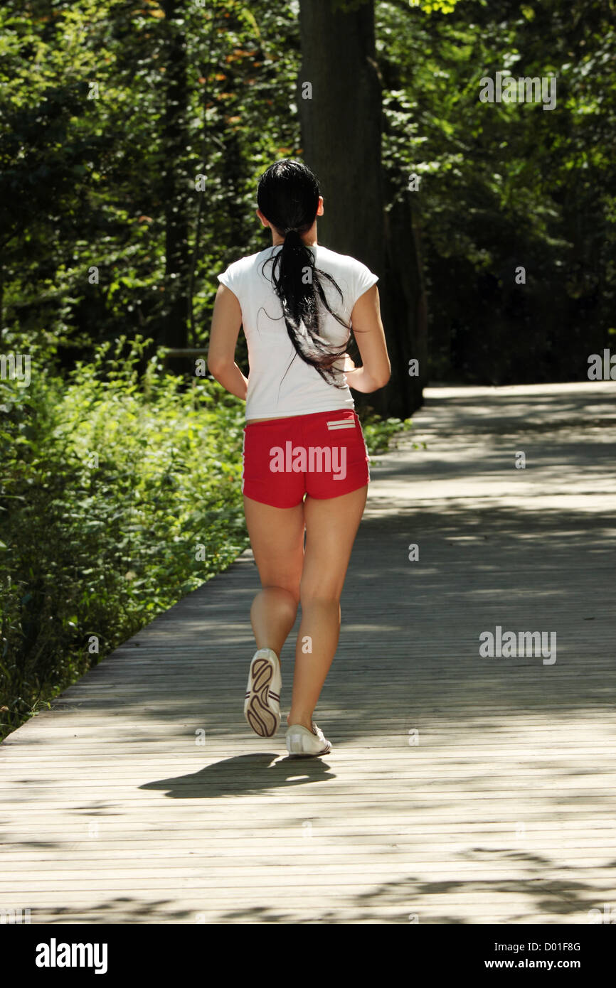 Young woman running outdoors in green park on sunny summer day Stock ...