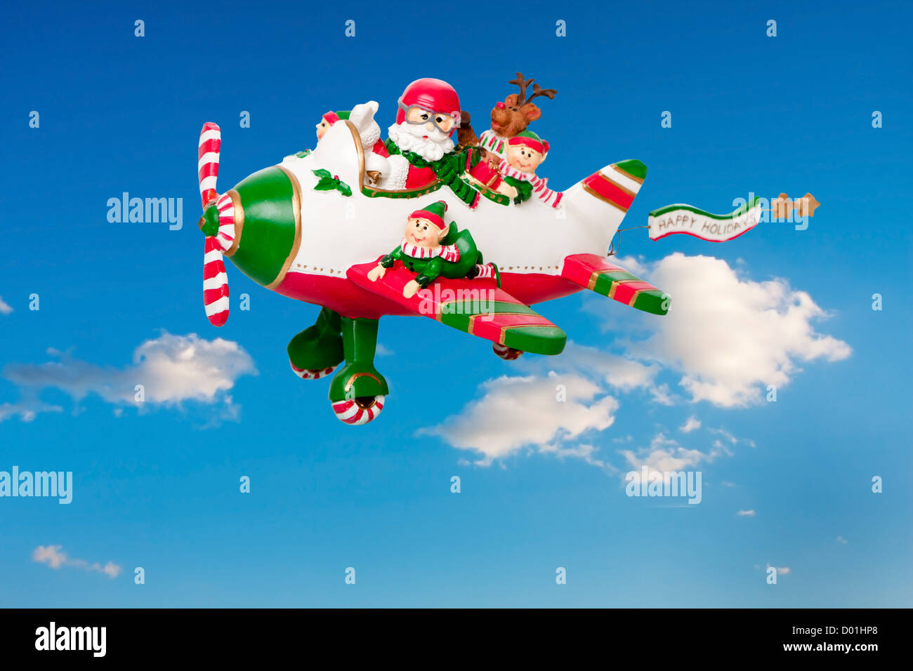 Santa Claus flying his airplane with Happy Holidays banner in the sky ...
