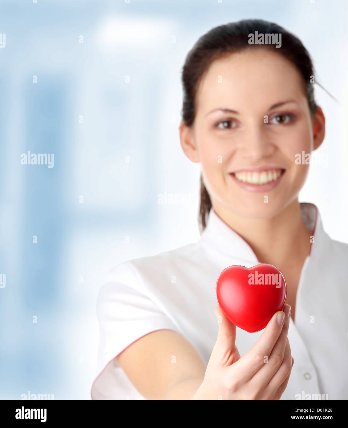 Young nurse with heart in her hand, isolated on white background Stock ...