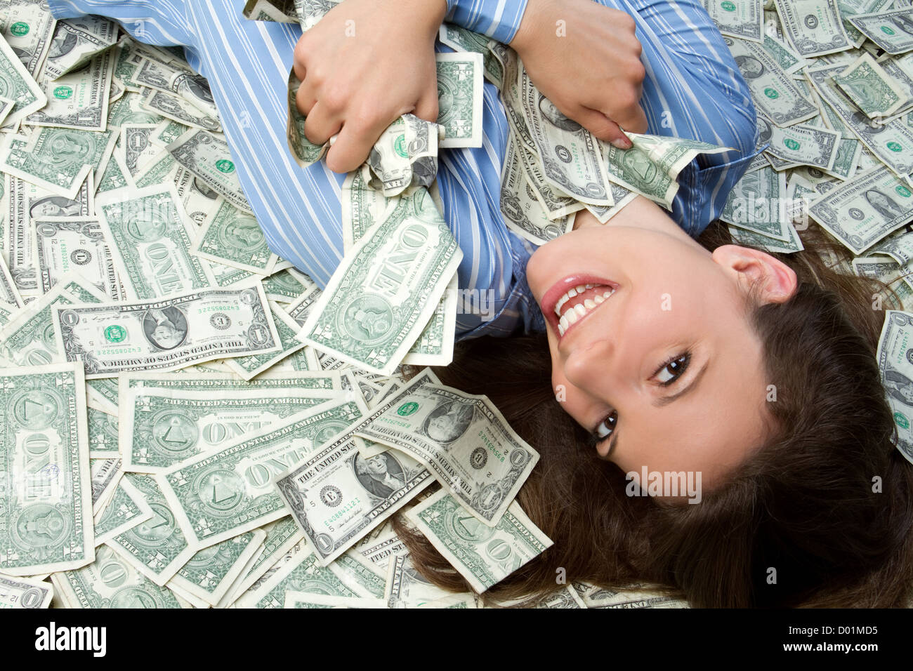 Beautiful woman laying in money Stock Photo - Alamy
