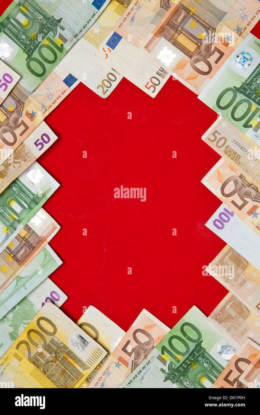Euro bills on red background,recorded above them Stock Photo - Alamy