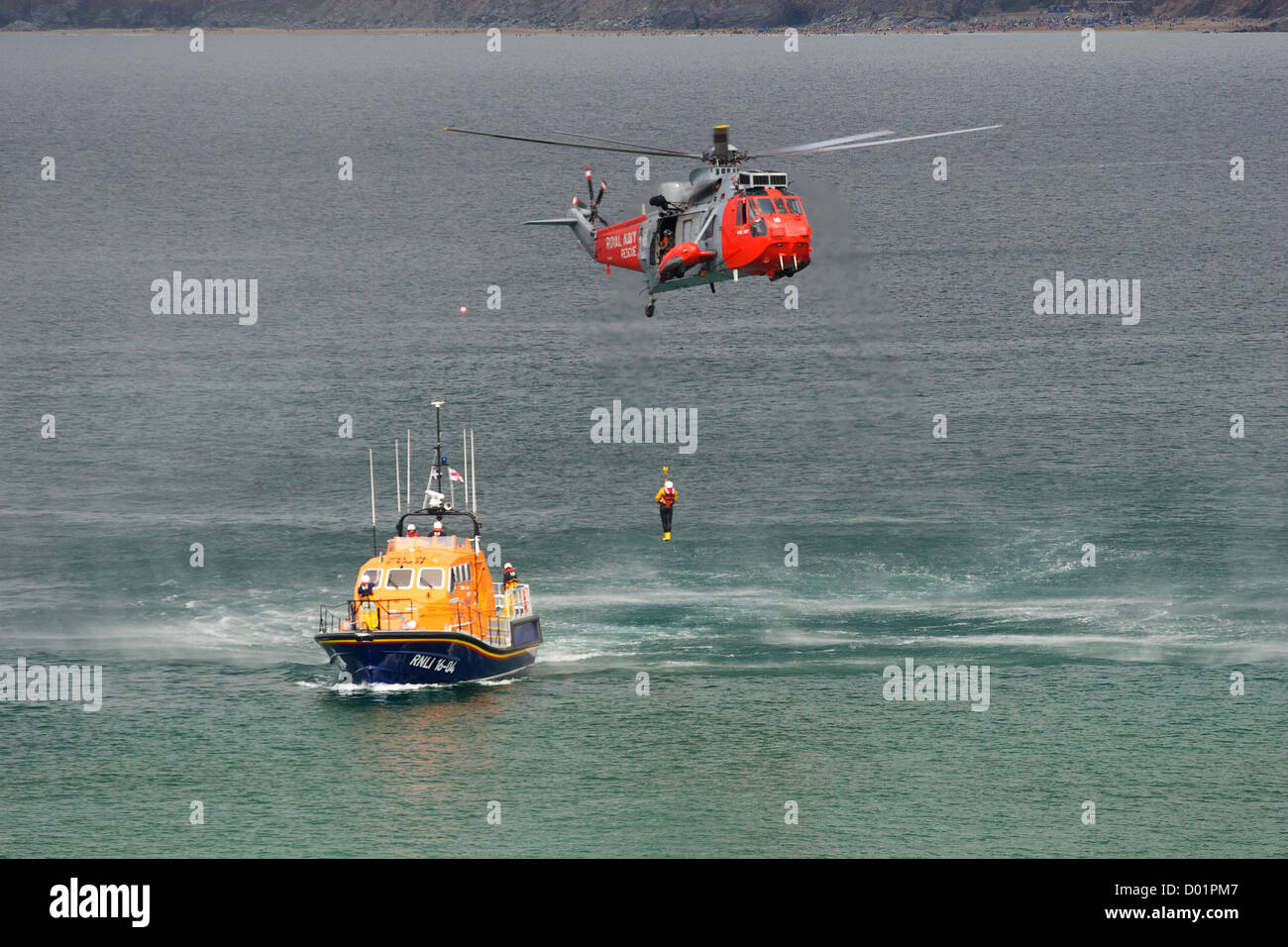 A winchman being lowered onto a lifeboat from a Search and Rescue ...