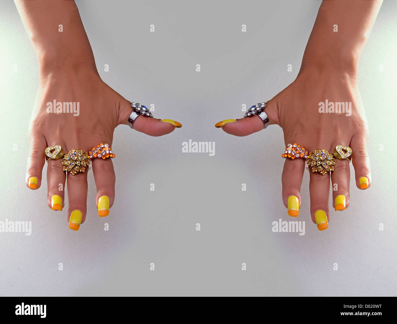 Hand showing big rings on fingers, colored nails Stock Photo - Alamy