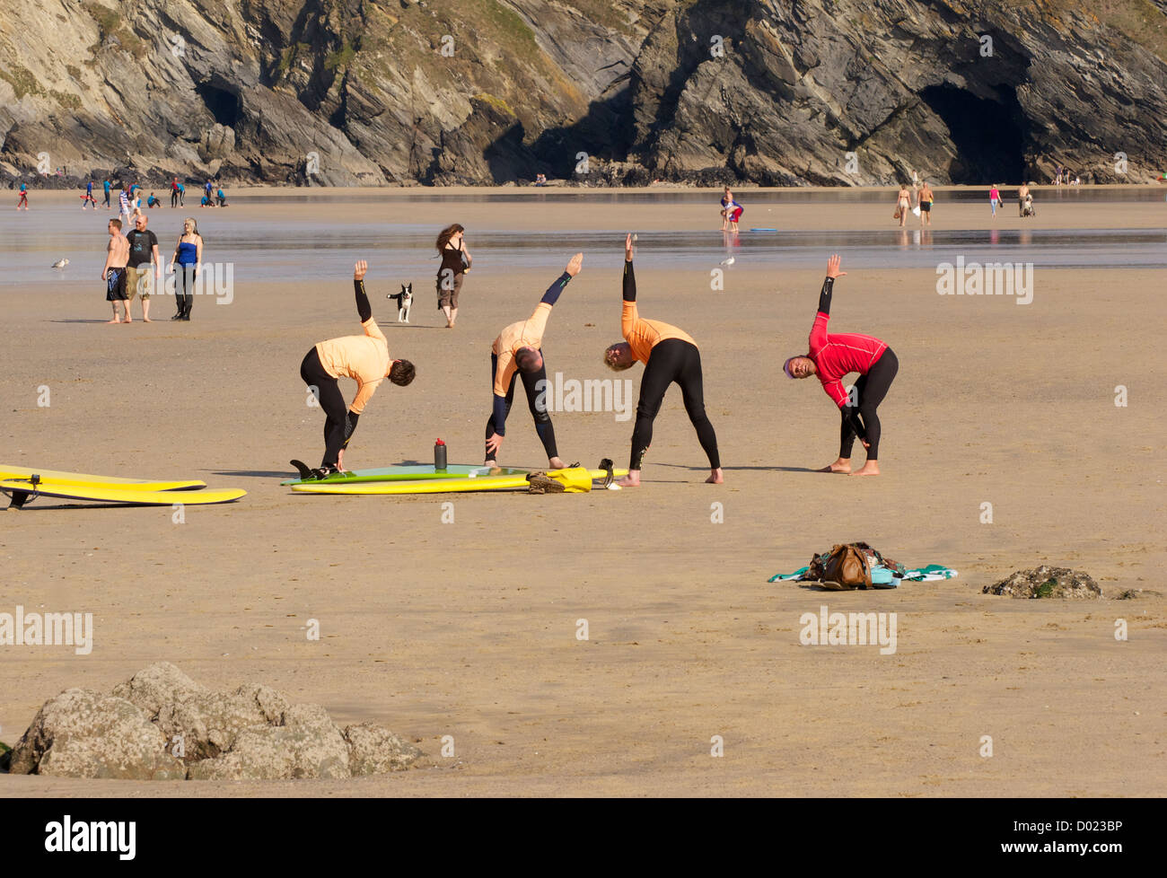Surfers doing their pre-surf exercises with their instructor at Newquay ...
