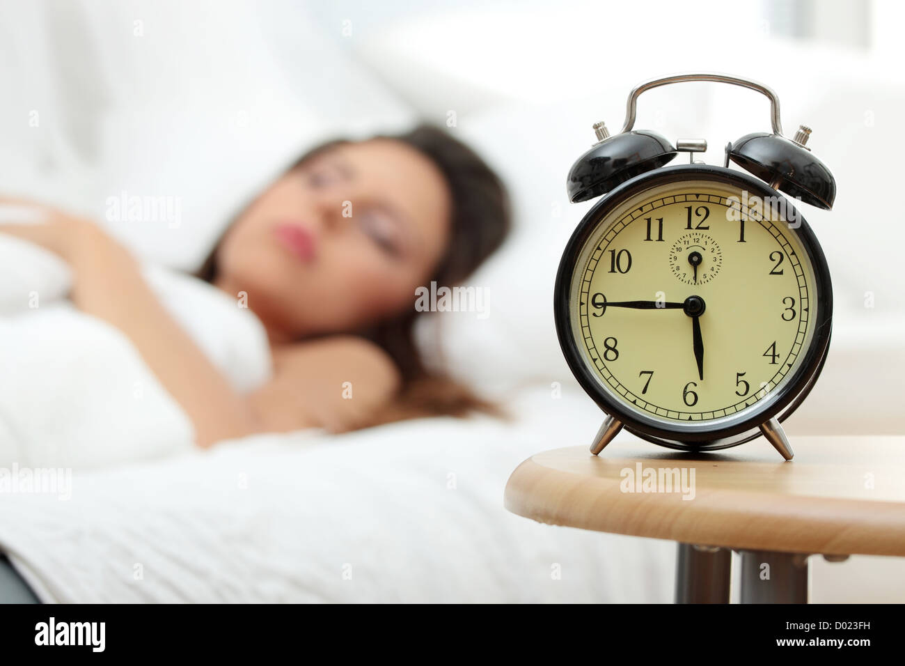 Beautiful Caucasian woman and alarmclock Stock Photo - Alamy