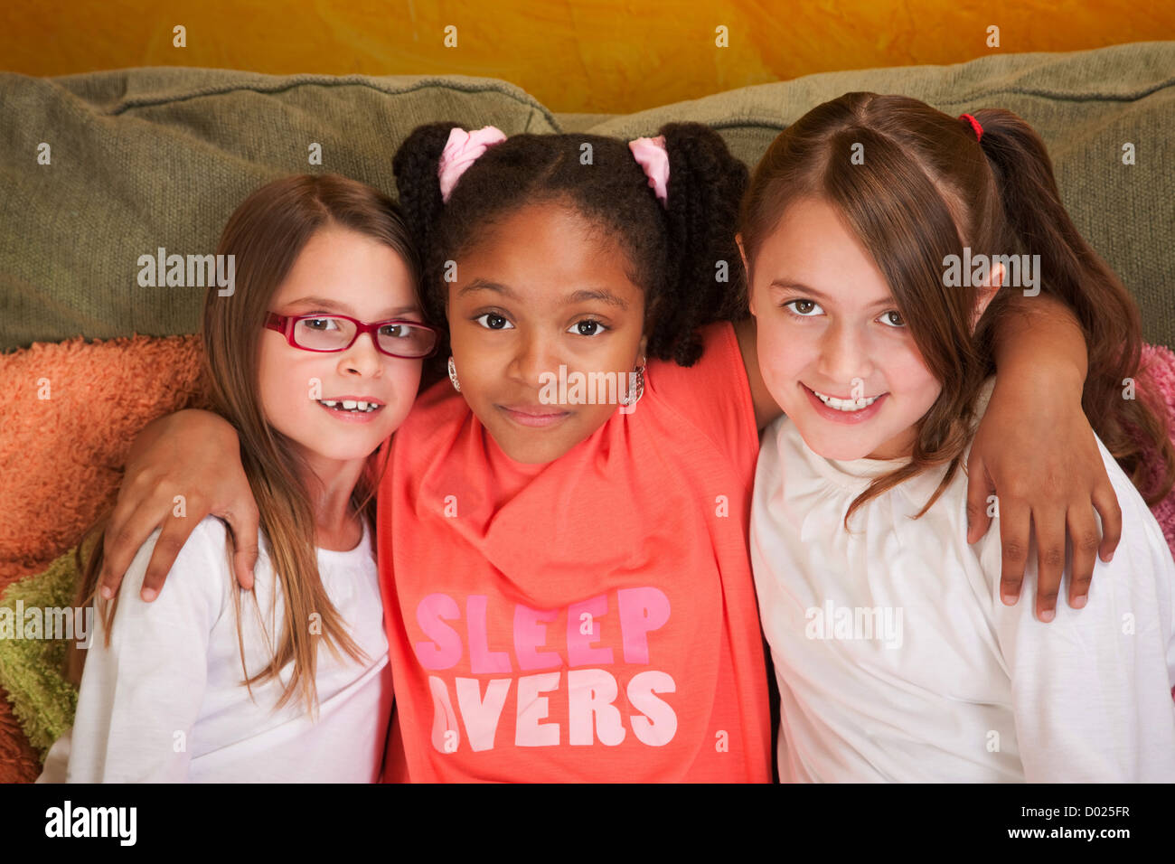 Three little friends hug each other on a couch Stock Photo - Alamy