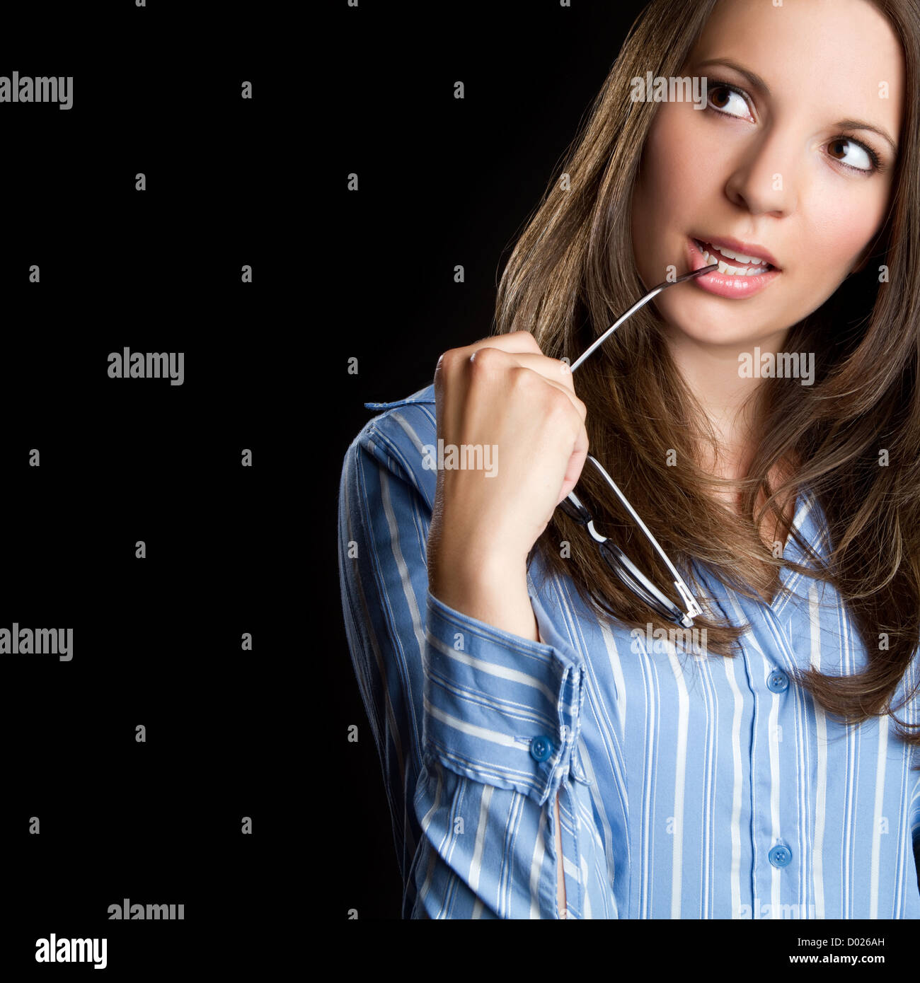 Pretty beautiful woman biting glasses Stock Photo - Alamy