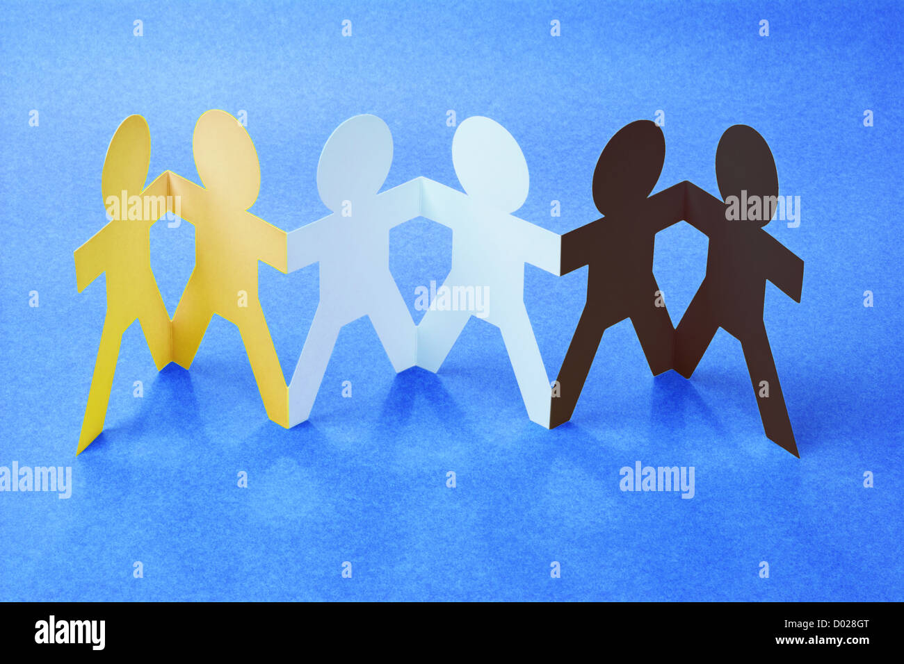 Row of Color Paper Chain figurines Holding Hands on Blue Background Stock Photo - Alamy