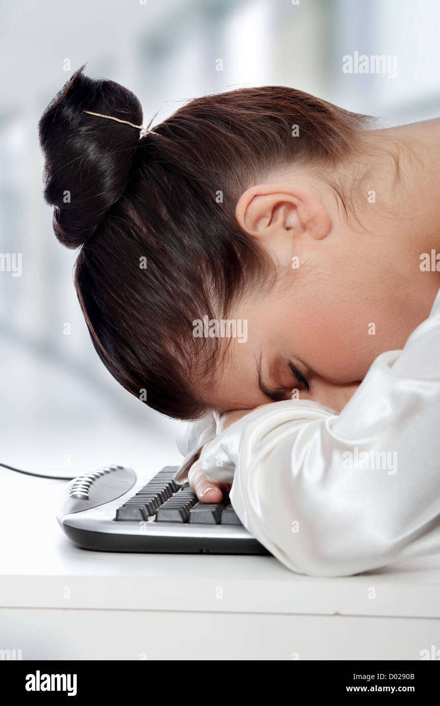 Young businesswoman sleeping on the keyboard in the office Stock Photo ...