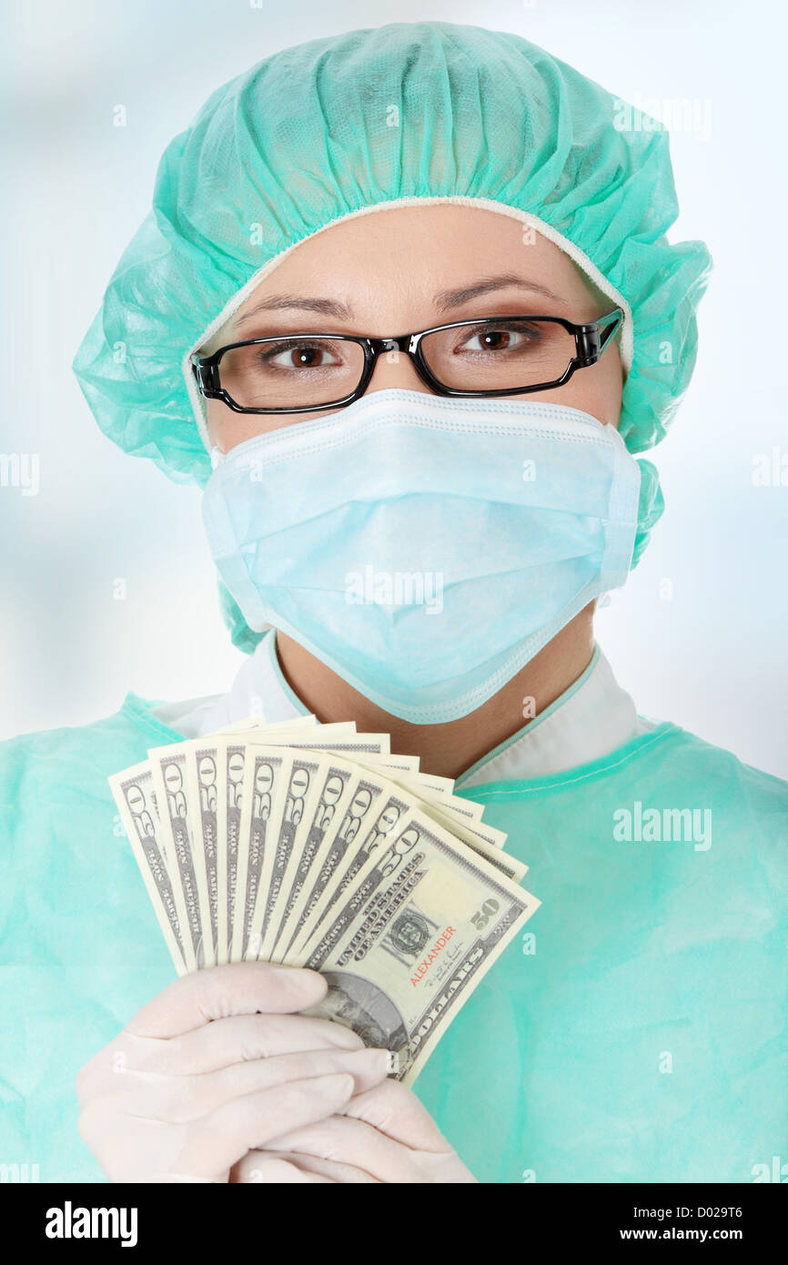 Female surgeon doctor holding money Stock Photo - Alamy