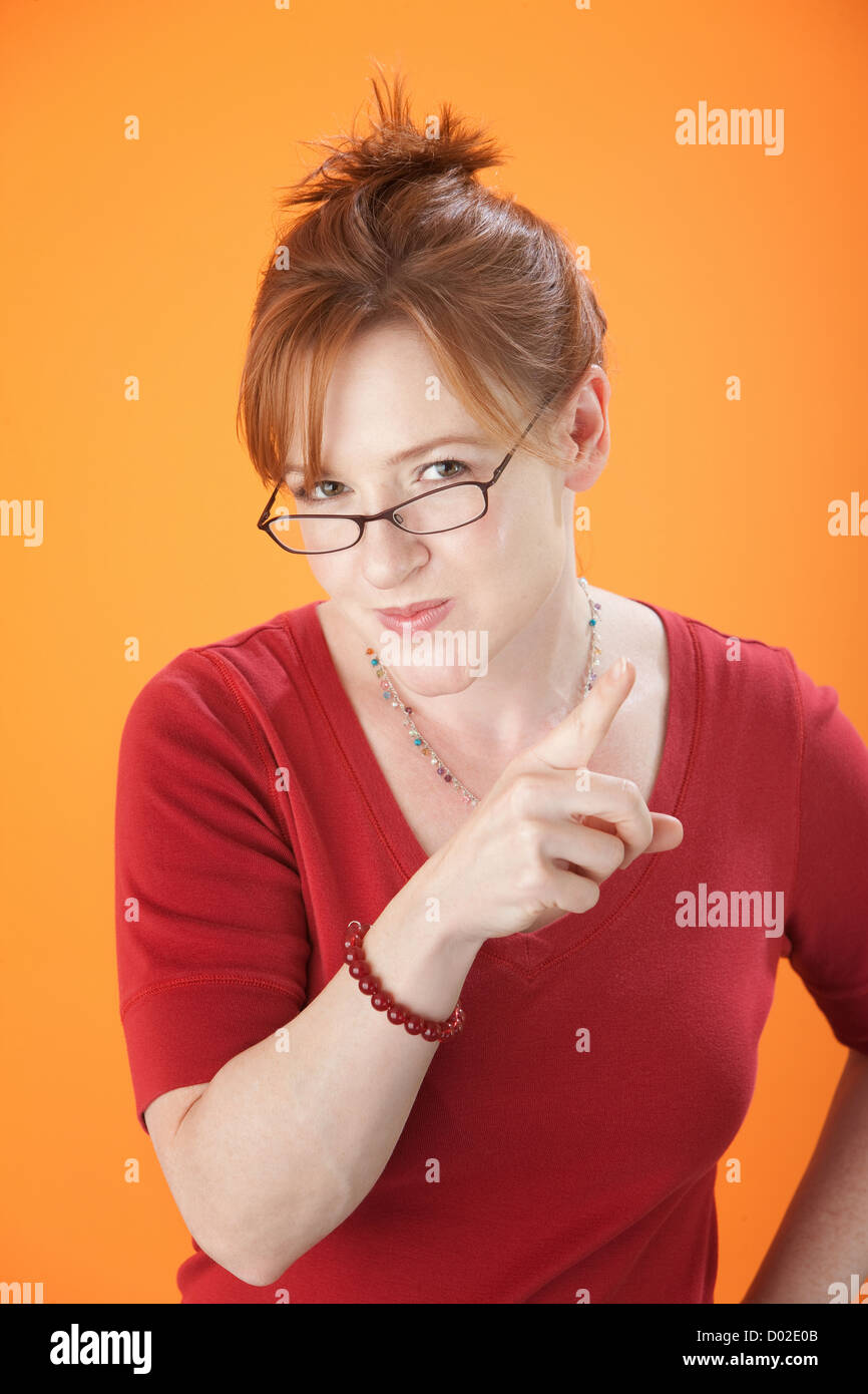 Caucasian lady with glasses pointing her finger Stock Photo - Alamy