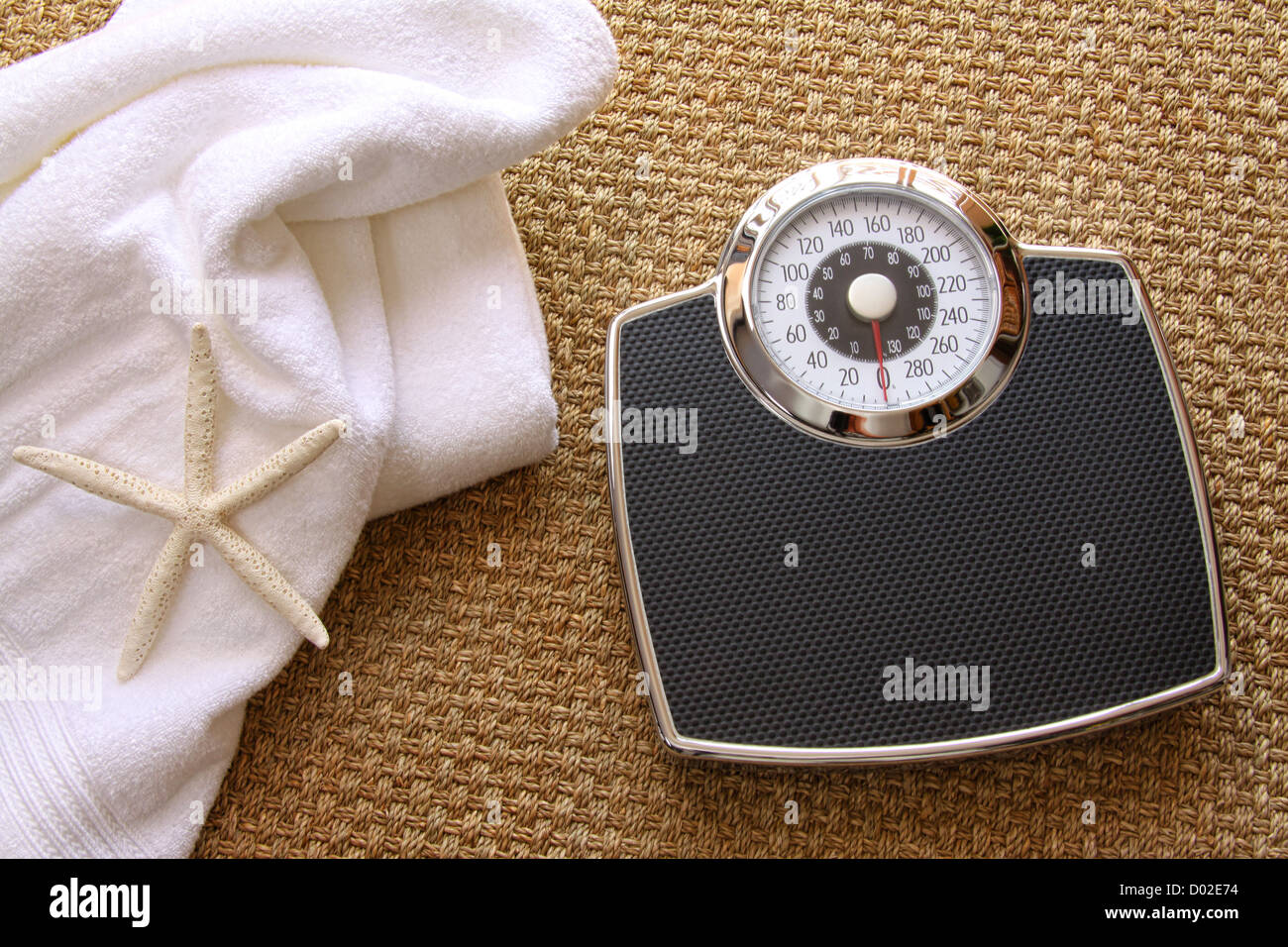 Weight scale with white towel on seagrass carpet Stock Photo - Alamy