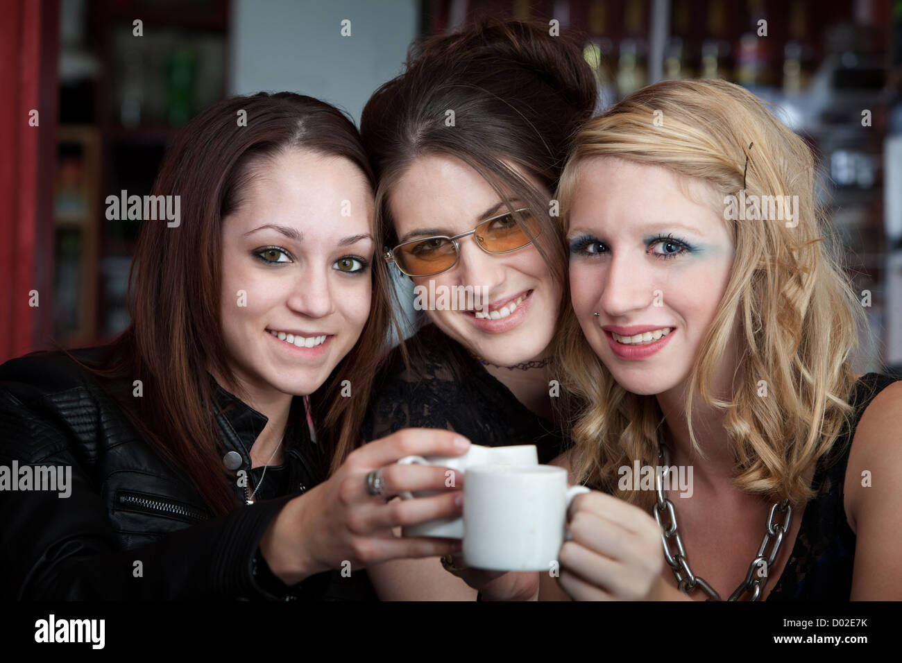 Three cute teenaged friends smiling and saying cheers over coffee Stock ...