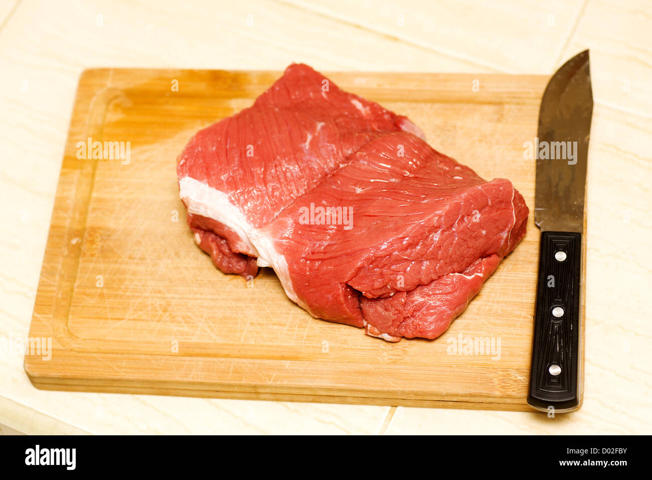 Raw fresh beef on wooden board wuth sharp knife Stock Photo - Alamy