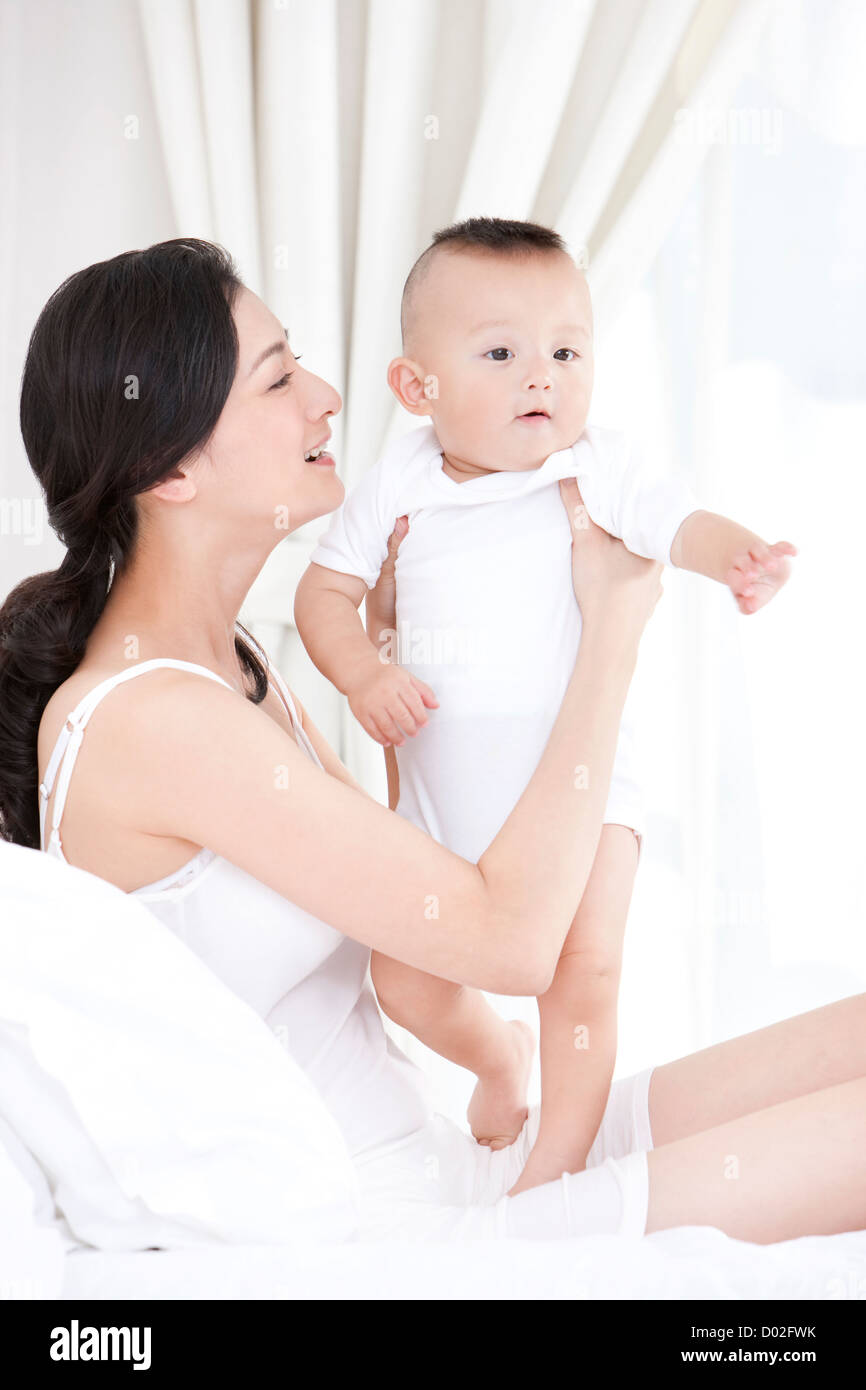 Mother lifting up cute baby gently Stock Photo - Alamy