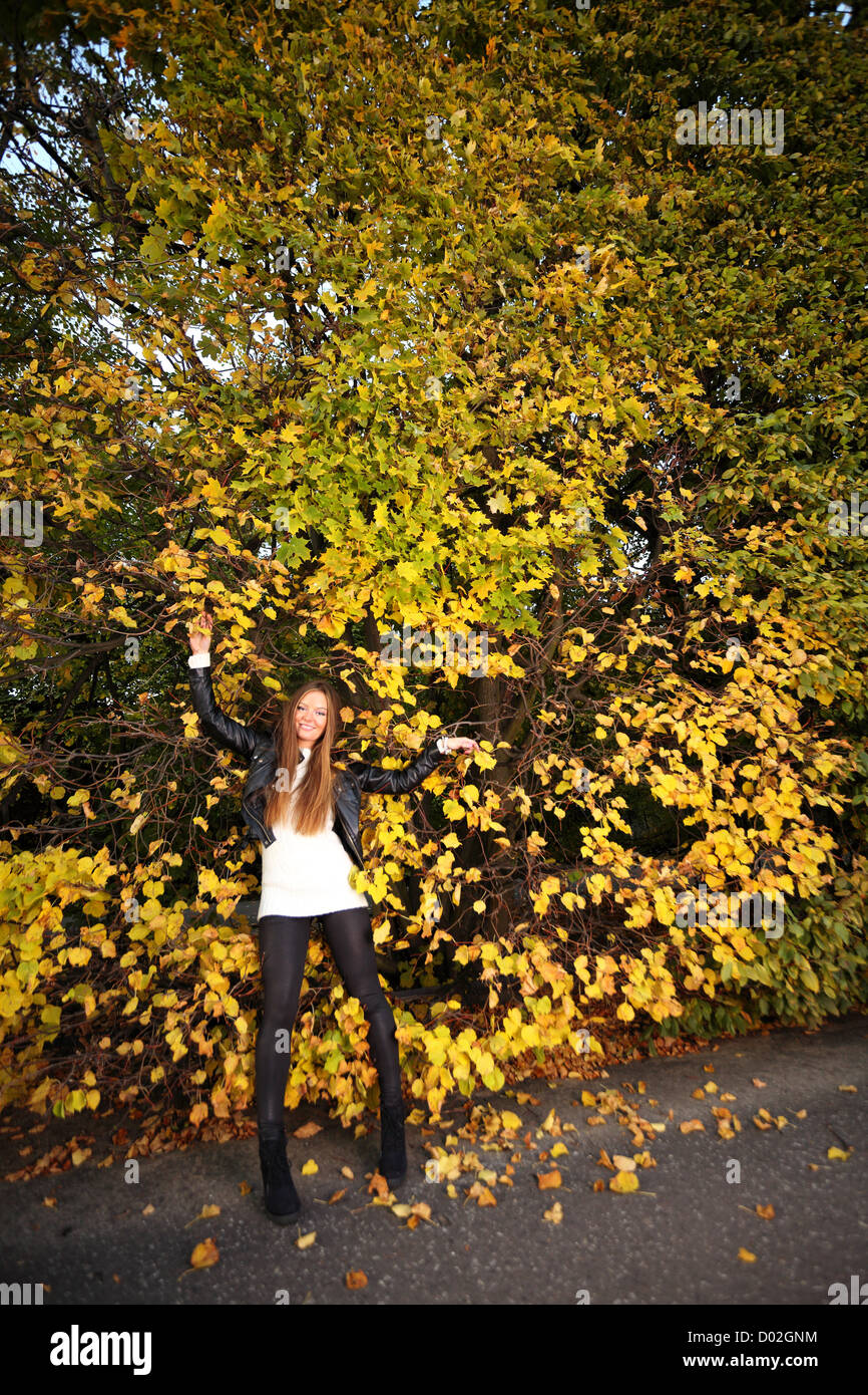 Young woman stand autumn leaves fall yellow green girl garden ...