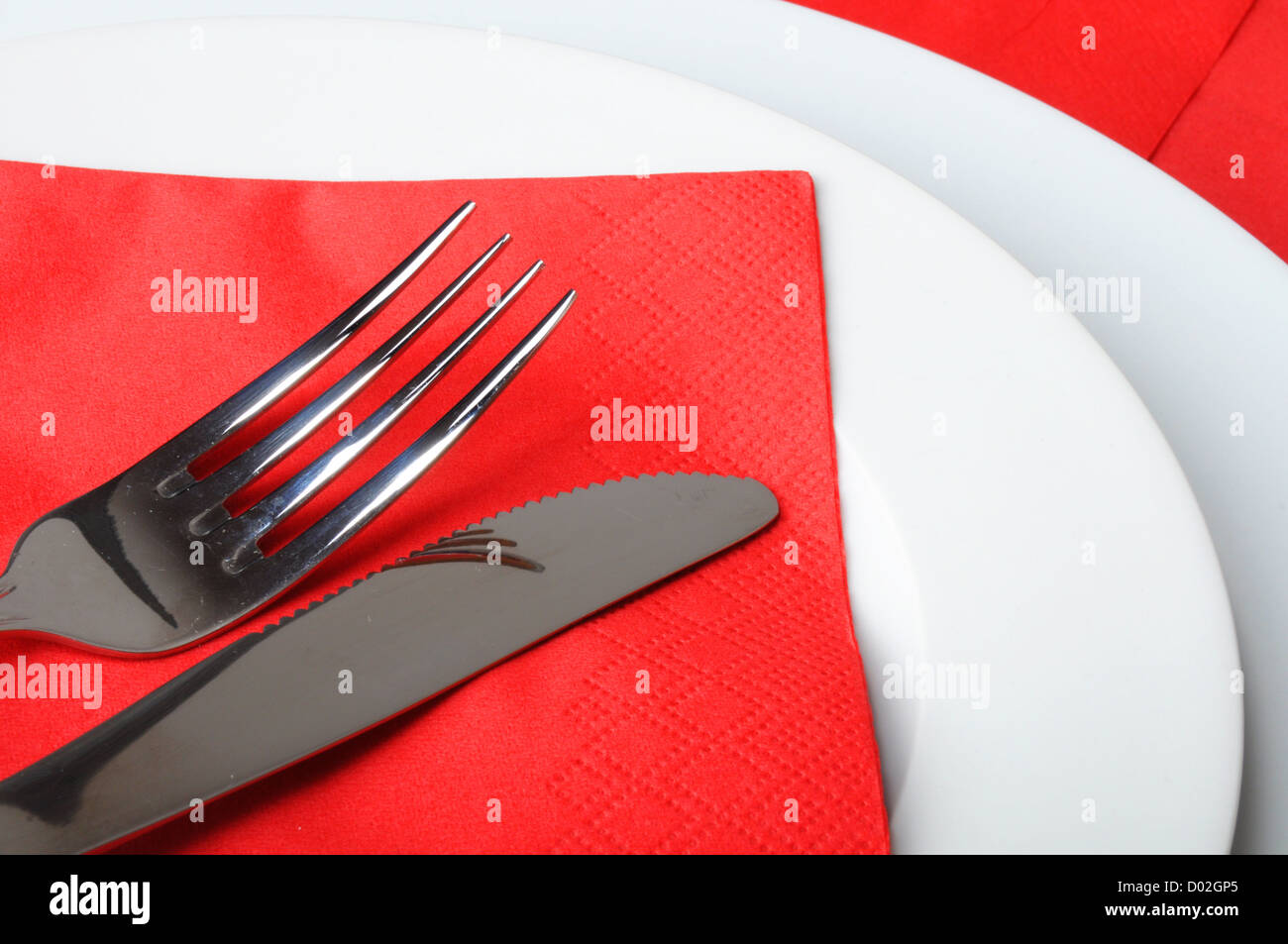 stainless fork knife and plate set on a table Stock Photo - Alamy