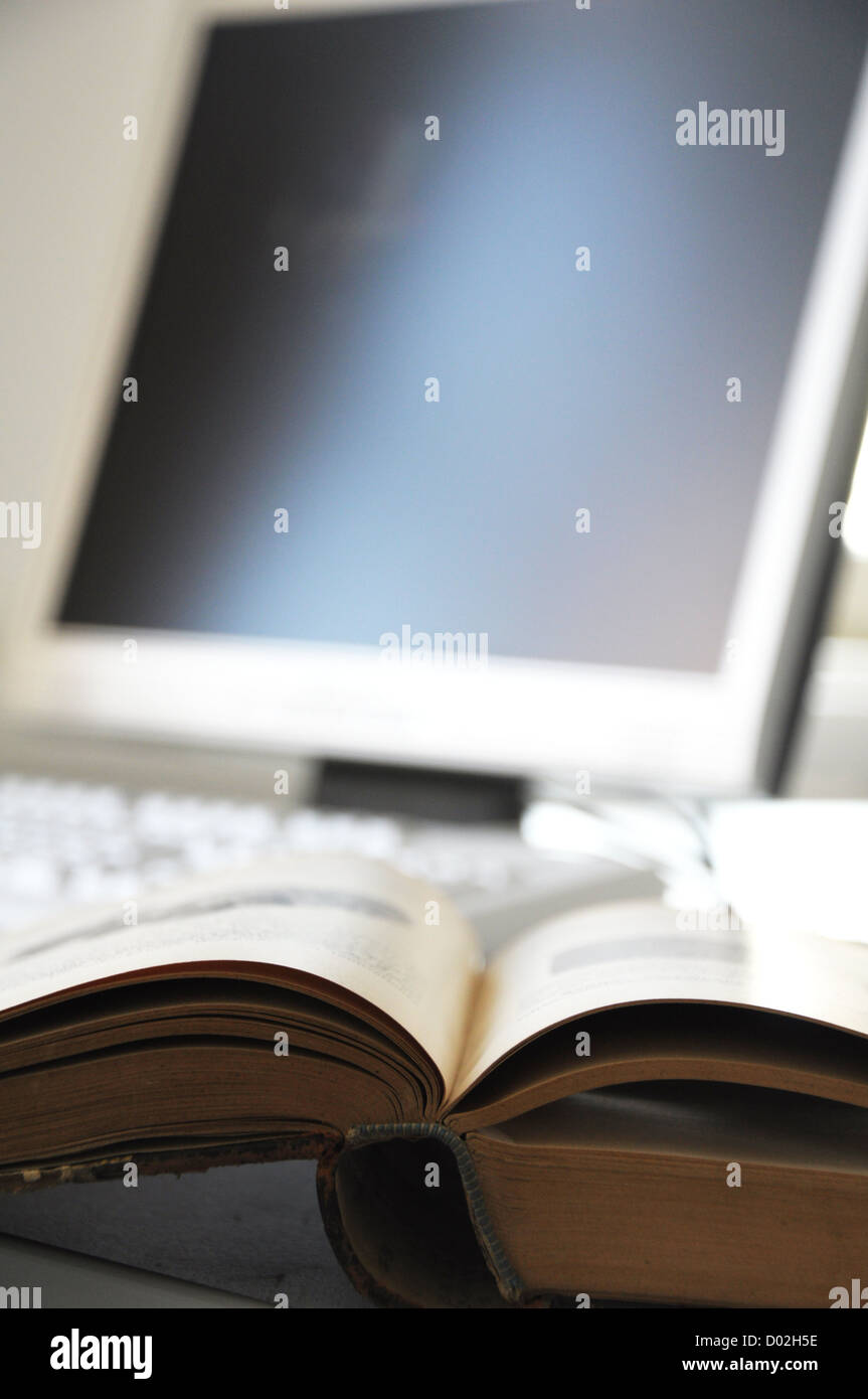 old books and computer on a desk in a library Stock Photo - Alamy