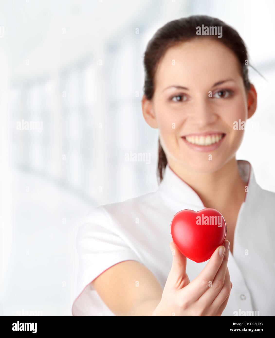 Young nurse with heart in her hand Stock Photo - Alamy