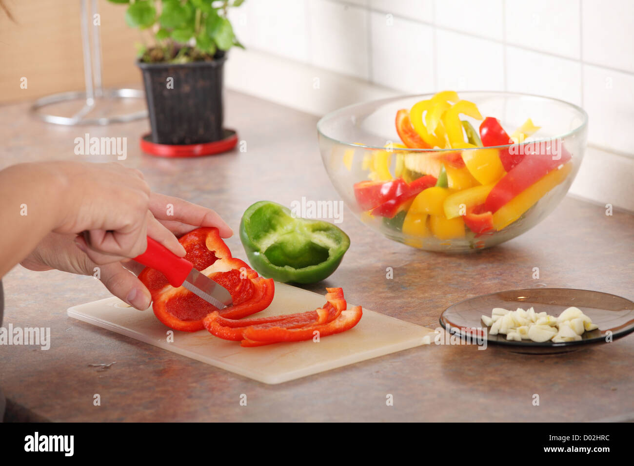 Female chopping food ingredients (paprika) on the kitchen Stock Photo ...