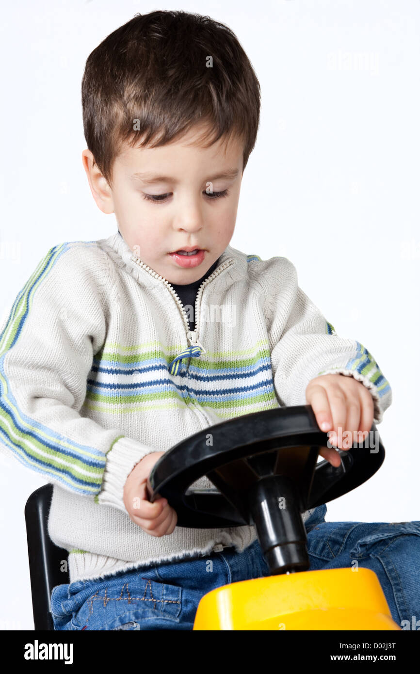 Boy driving a toy car isolated on white background Stock Photo - Alamy