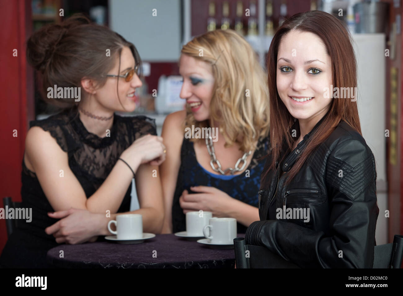 Three friends chit-chatting over a cup of coffee in a cafe Stock Photo ...
