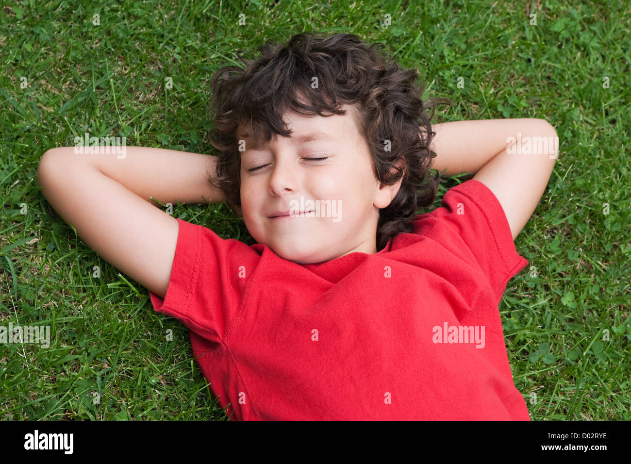 Boy asleep on grass hi-res stock photography and images - Alamy