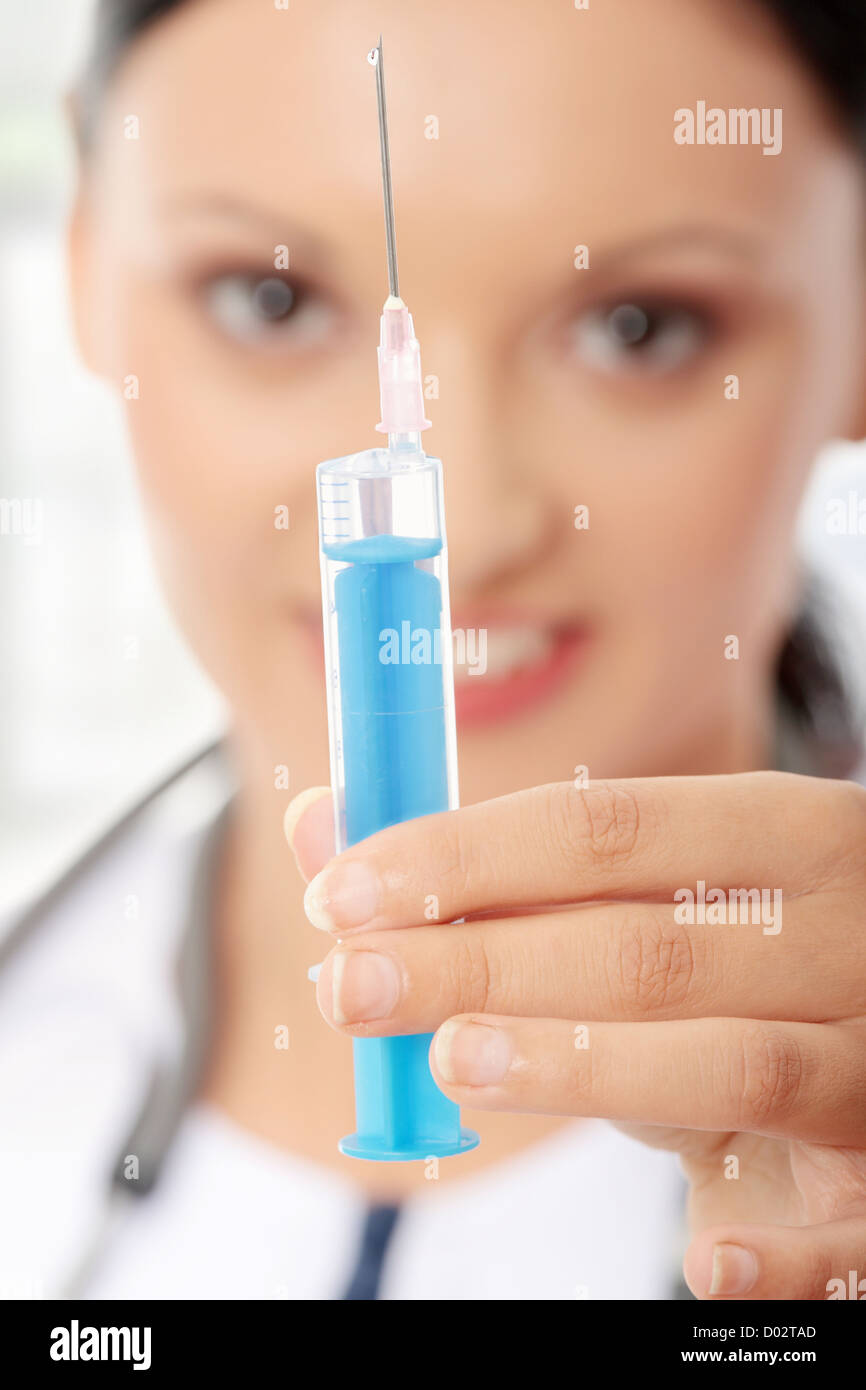 Young female doctor or nurse holding syringe - focus on syringe Stock ...