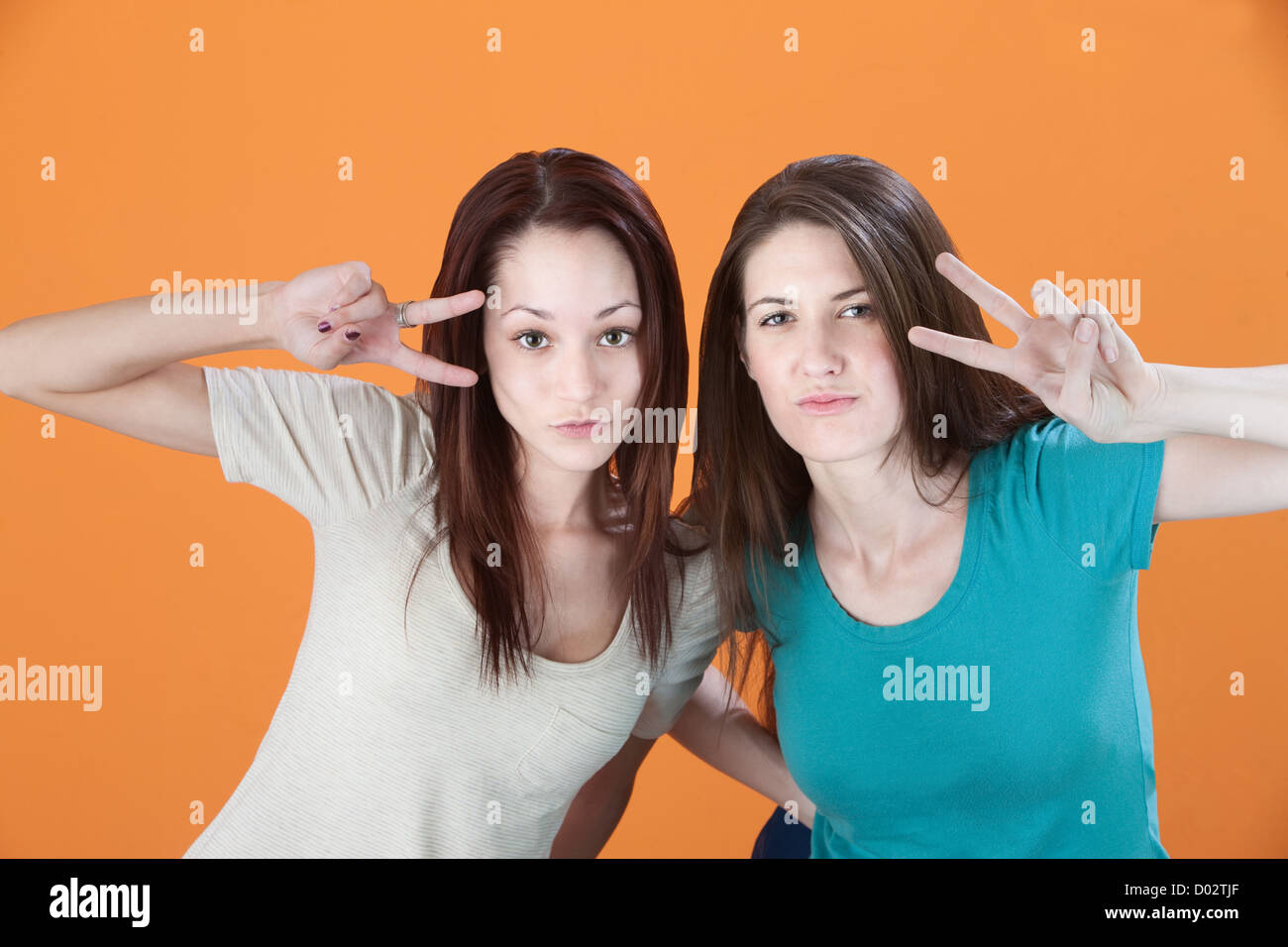 Two young friends show a victory or peace sign Stock Photo - Alamy