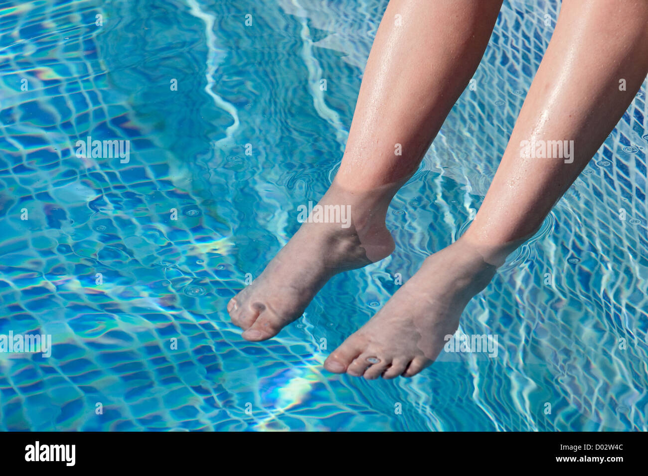 Feet refreshing in swimming pool in summer Stock Photo - Alamy