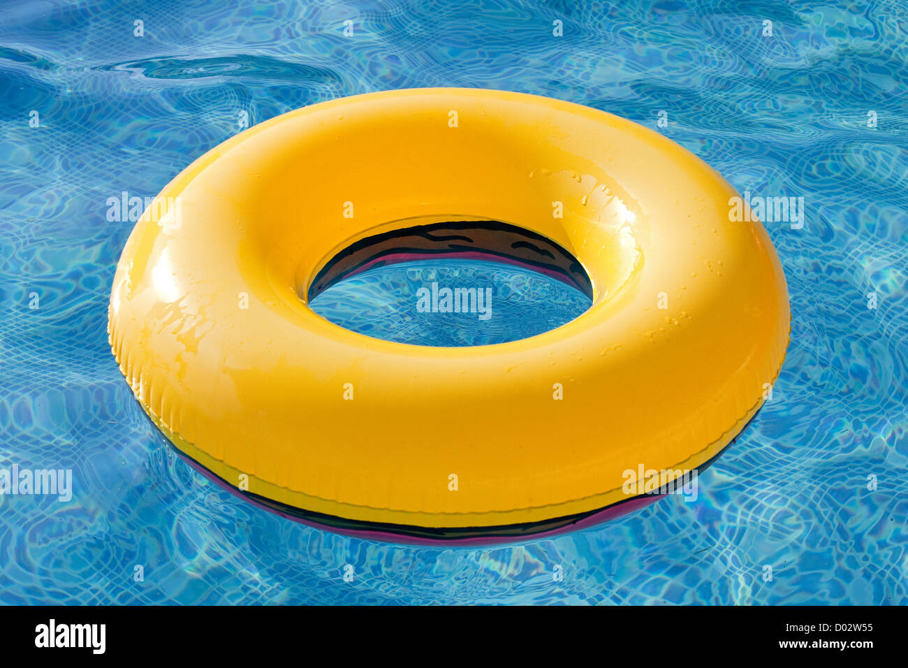 Yellow float floating in the pool with blue water Stock Photo - Alamy