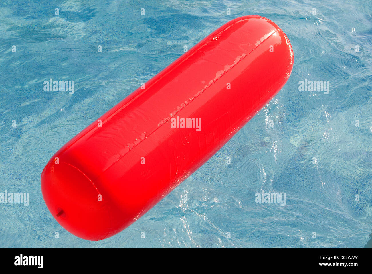 Red float floating in the pool with blue water Stock Photo - Alamy