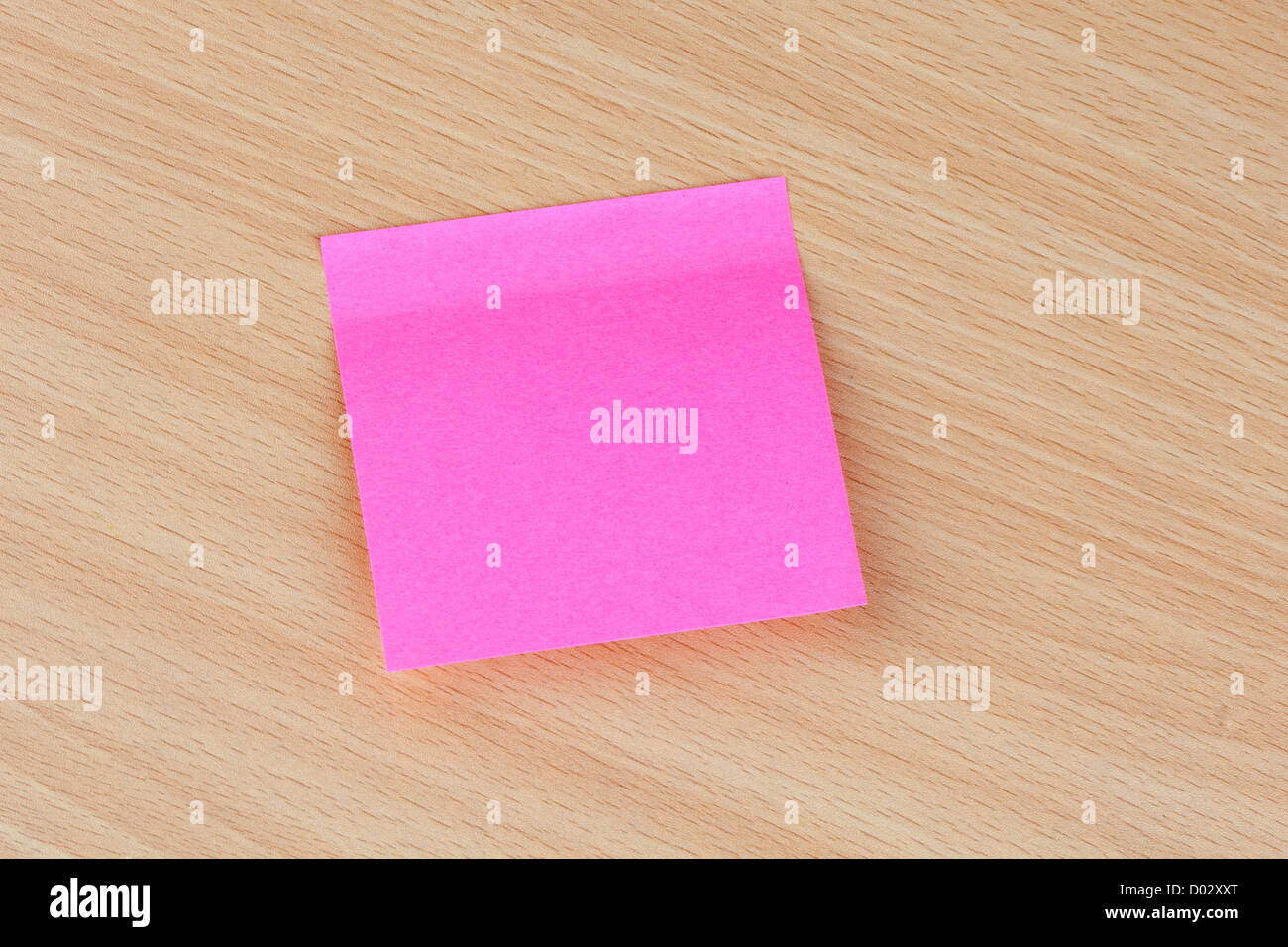 Pink Post-it stuck on a wooden surface Stock Photo - Alamy