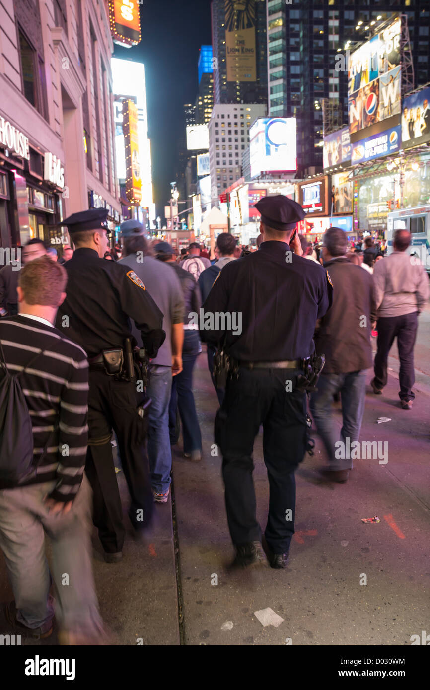 Two police officers walking in Time Square, New York by night Stock ...
