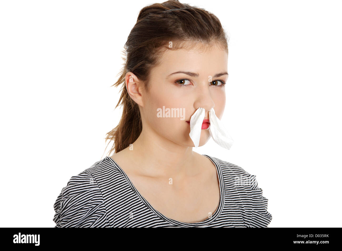 Teen woman with tissue in her nose, isolated on white background Stock ...