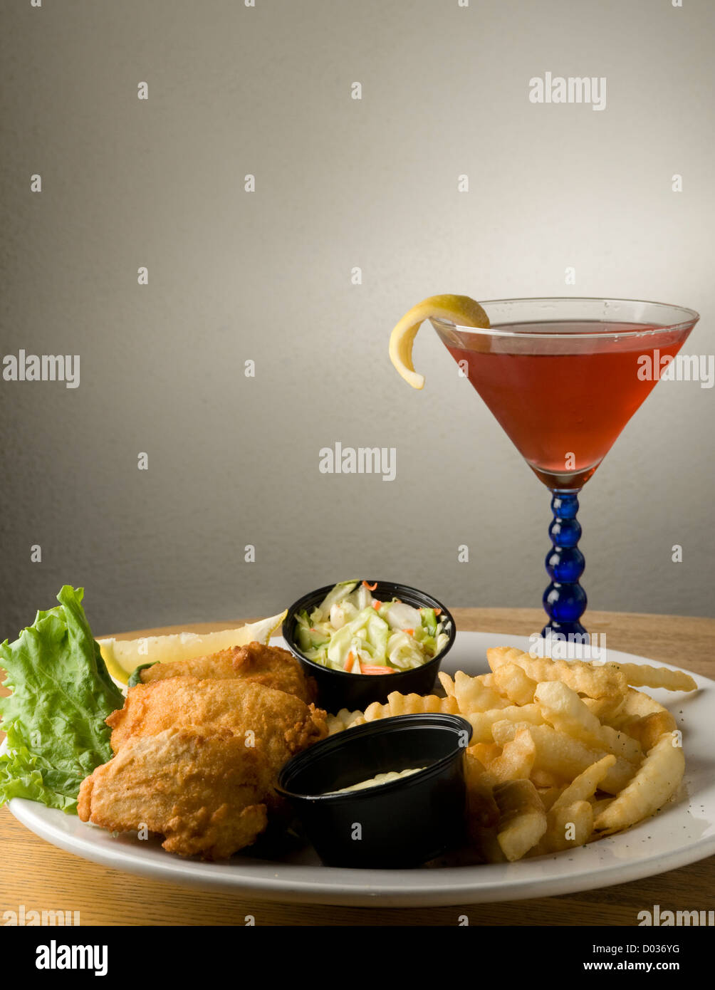 Fish and chips dish served with Manhattan cocktail Stock Photo - Alamy