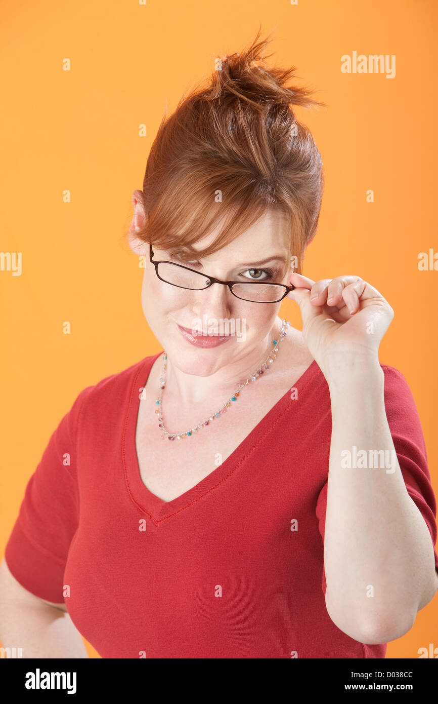 Beautiful Caucasian woman looks sneakily from over her eyeglasses Stock ...