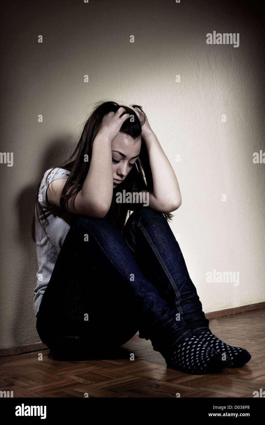 Depressed teenager girl sitting on floor Stock Photo - Alamy