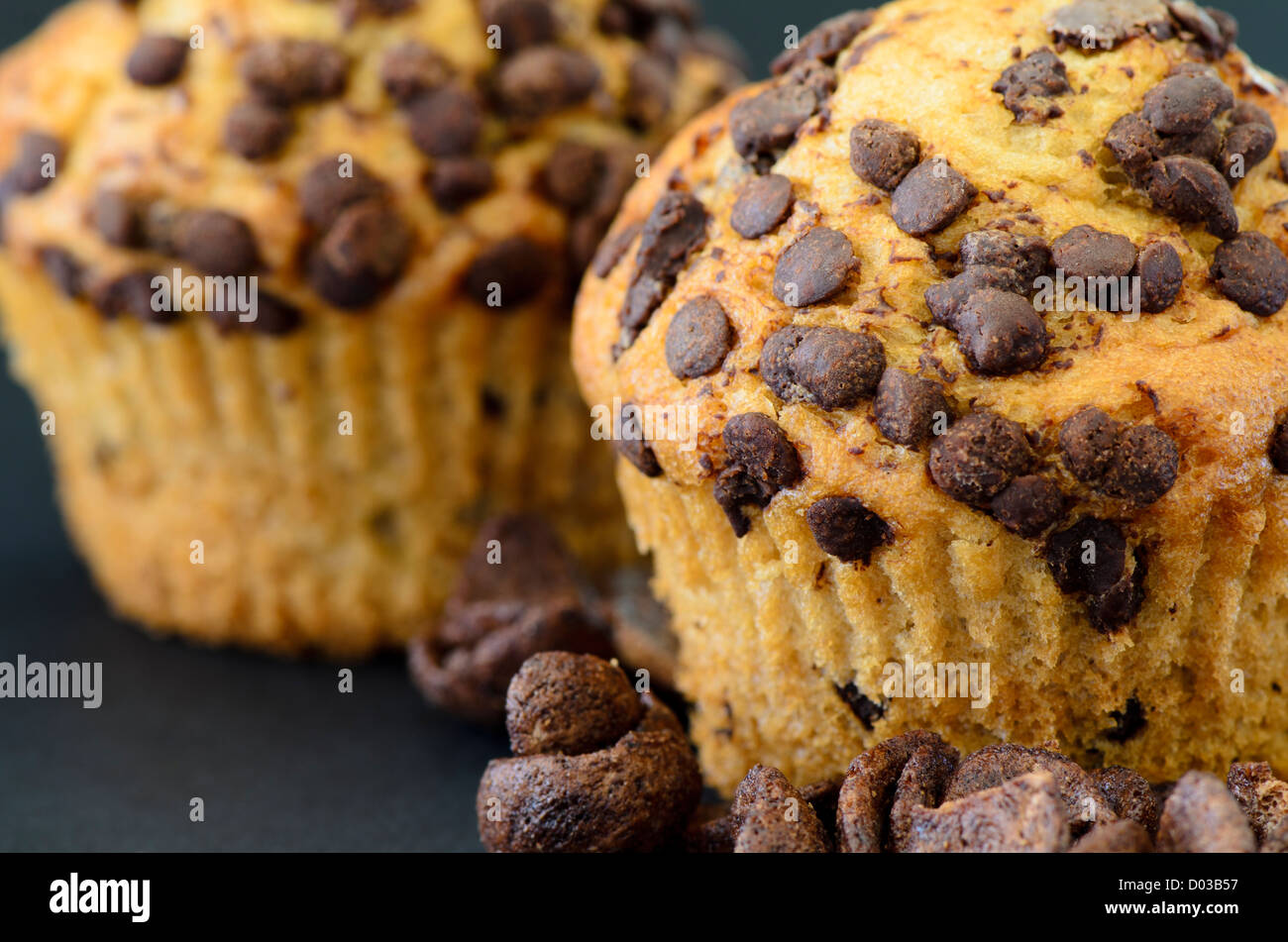 two muffins and chocolate pieces on black background Stock Photo - Alamy
