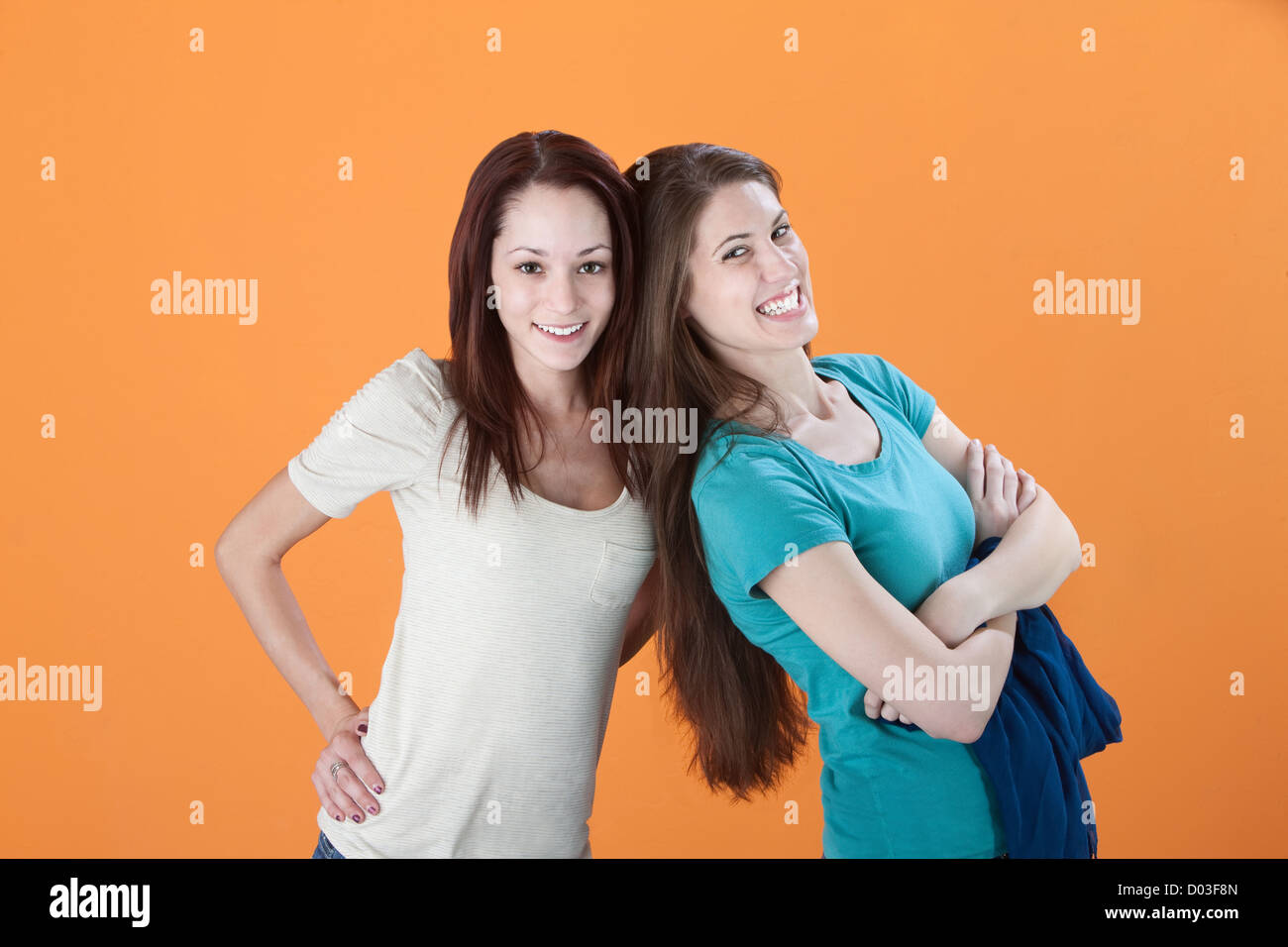 Gorgeous girlfriends together on an orange background Stock Photo - Alamy