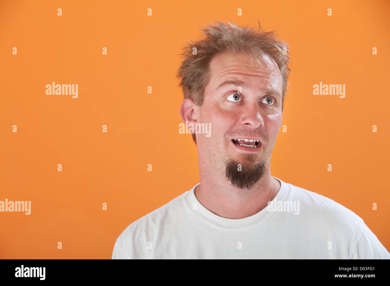 Disinterested Caucasian man with goatee on an orange background Stock ...