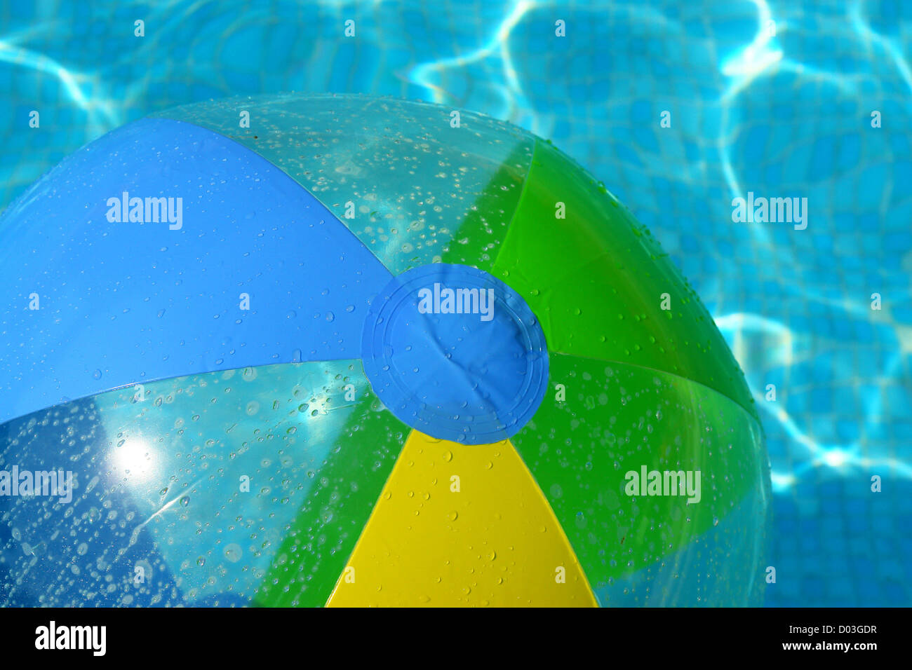 A colorful beach ball floating on the swimming pool Stock Photo - Alamy