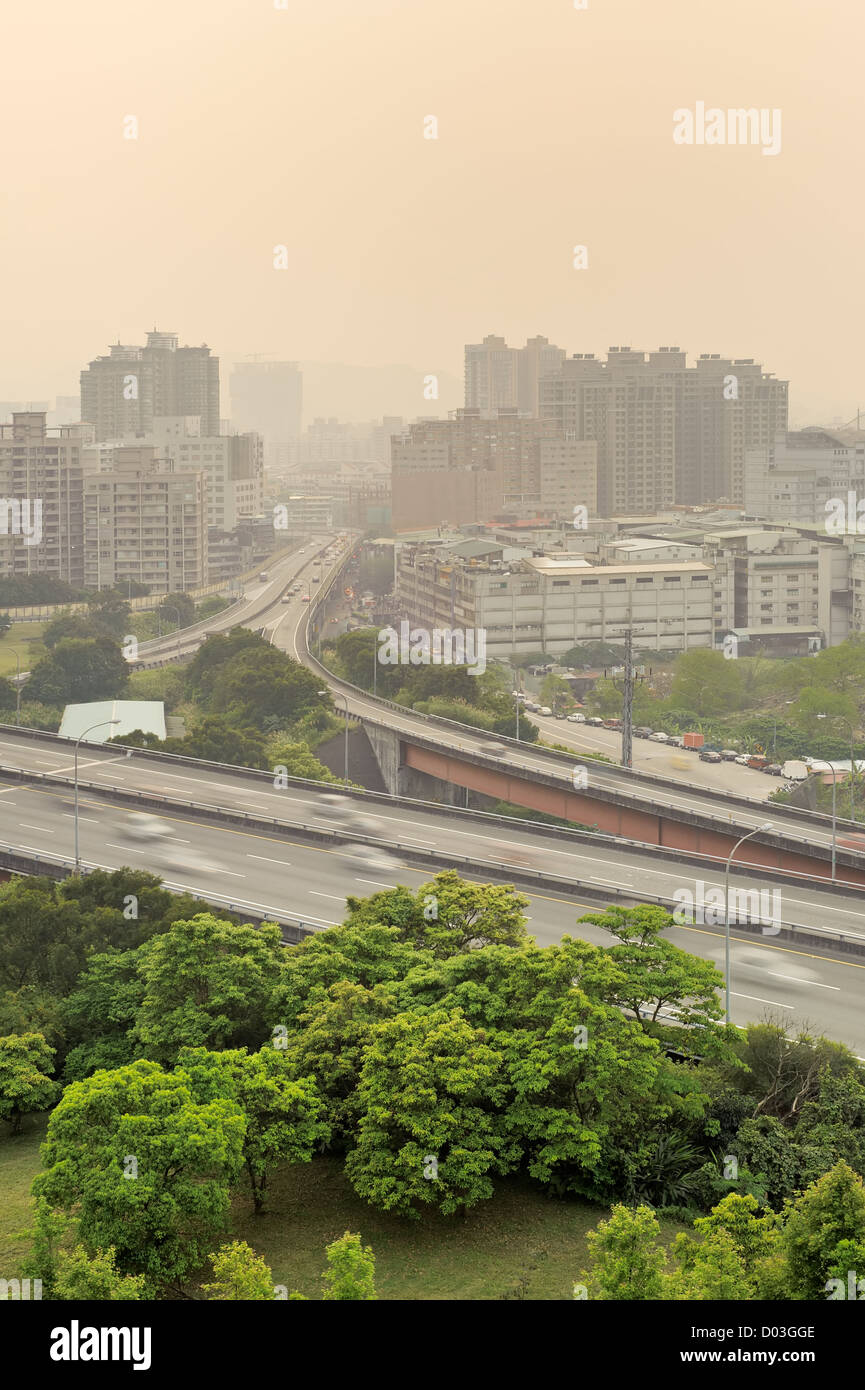 City scenery of sunset with buildings and high way under mist because ...