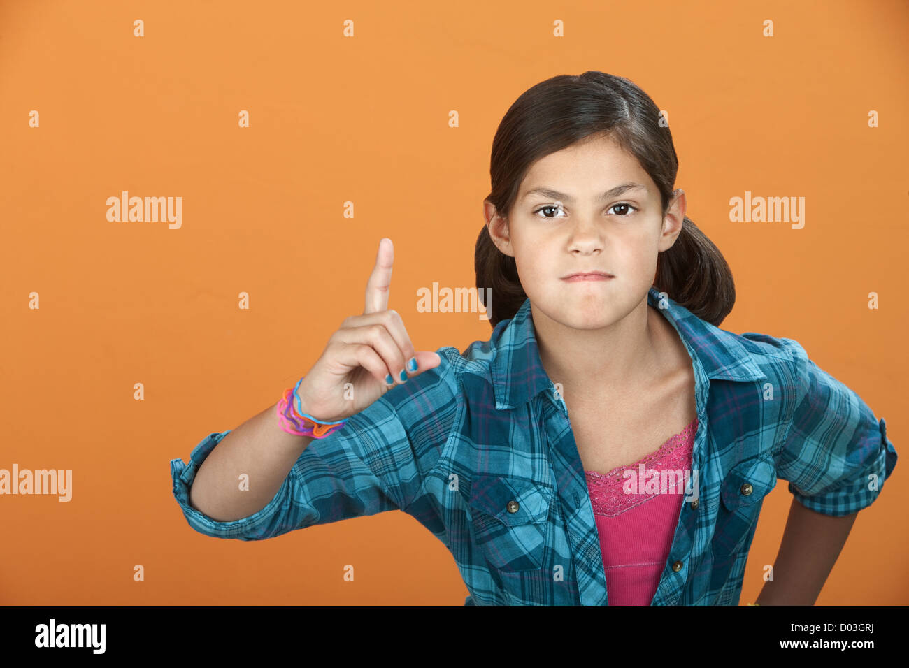 Fussy Latina child pointing index finger upward Stock Photo - Alamy