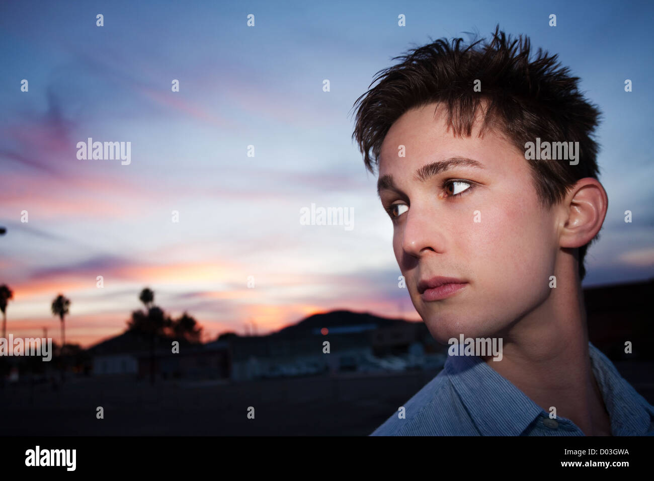 Serious young man looks over his shoulder Stock Photo - Alamy