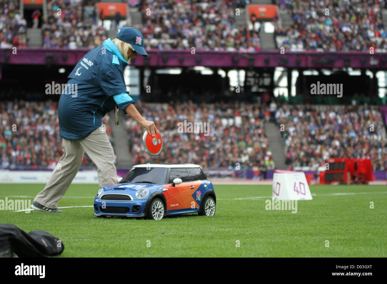 Umpire puts discus in the remote controlled mini car in the Men's ...